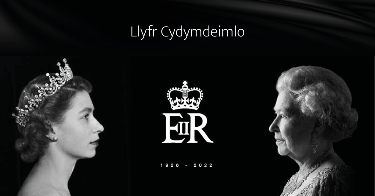 Mae llyfrau cydymdeimlo ar agor a fflagiau yn hedfan ar hanner mast ar ...